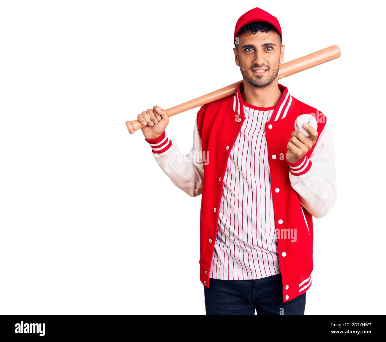 Young hispanic man playing baseball holding bat and ball looking ...