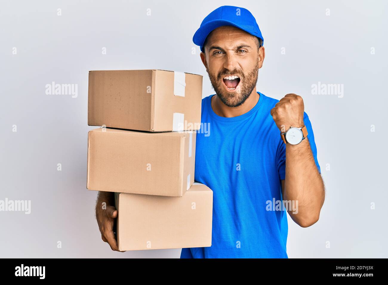 Handsome man with beard wearing courier uniform holding delivery ...