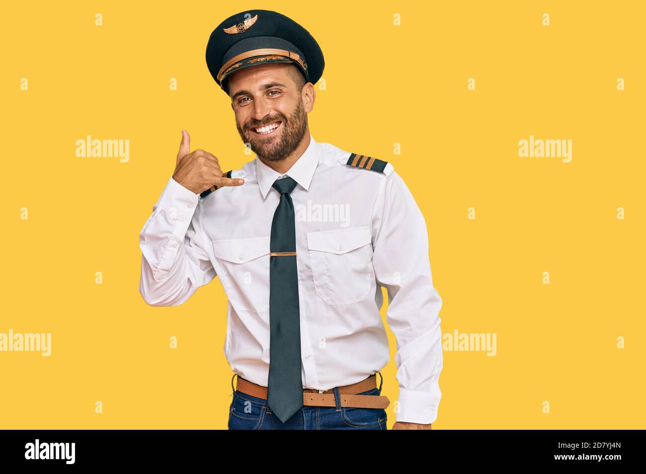 Handsome man with beard wearing airplane pilot uniform smiling doing ...