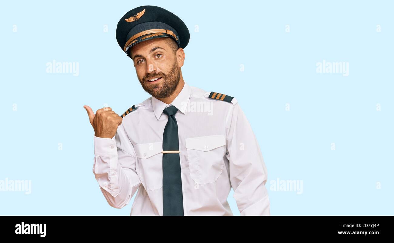 Handsome man with beard wearing airplane pilot uniform smiling with ...
