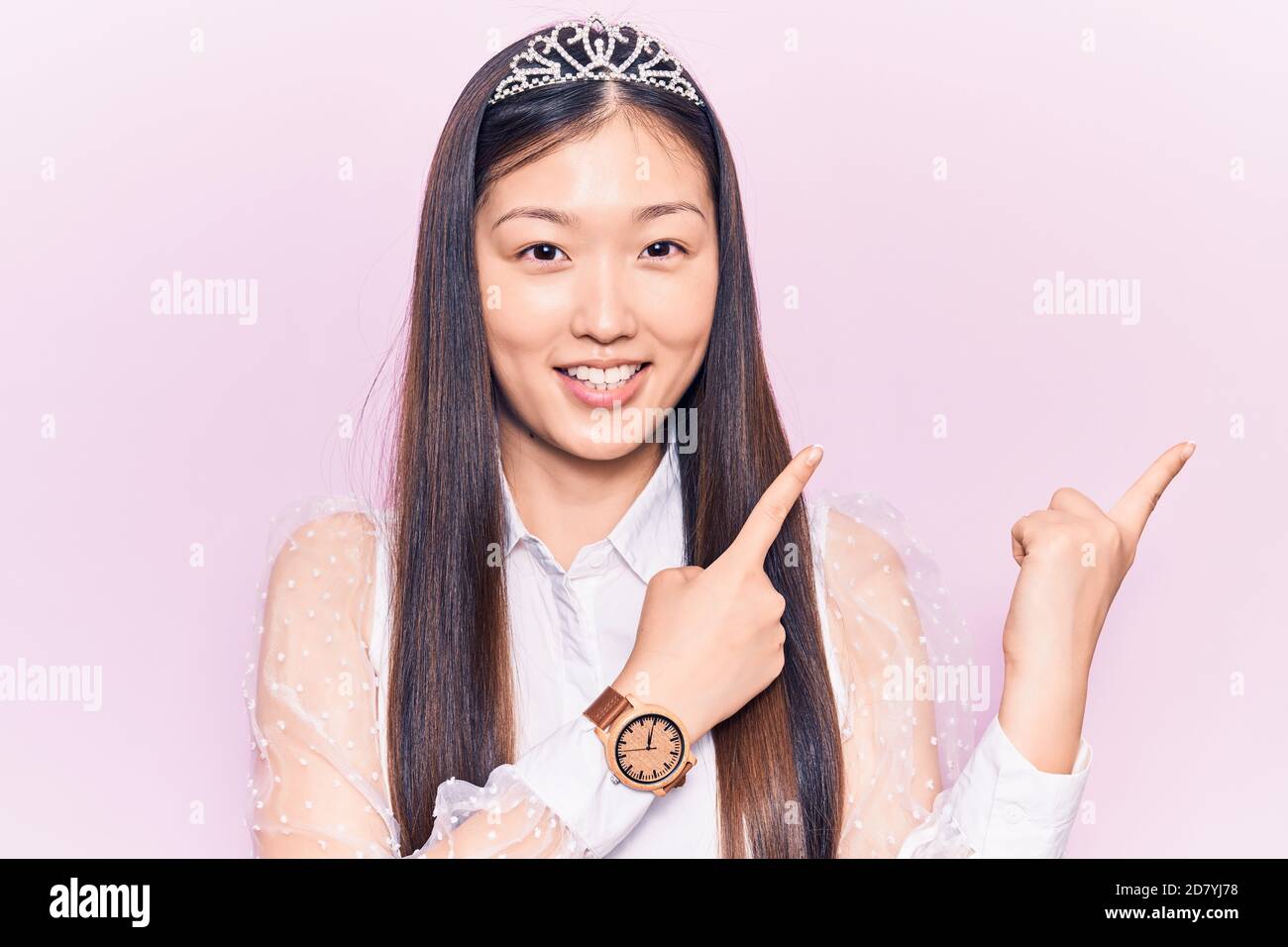 Young beautiful chinese woman wearing princess crown smiling and ...