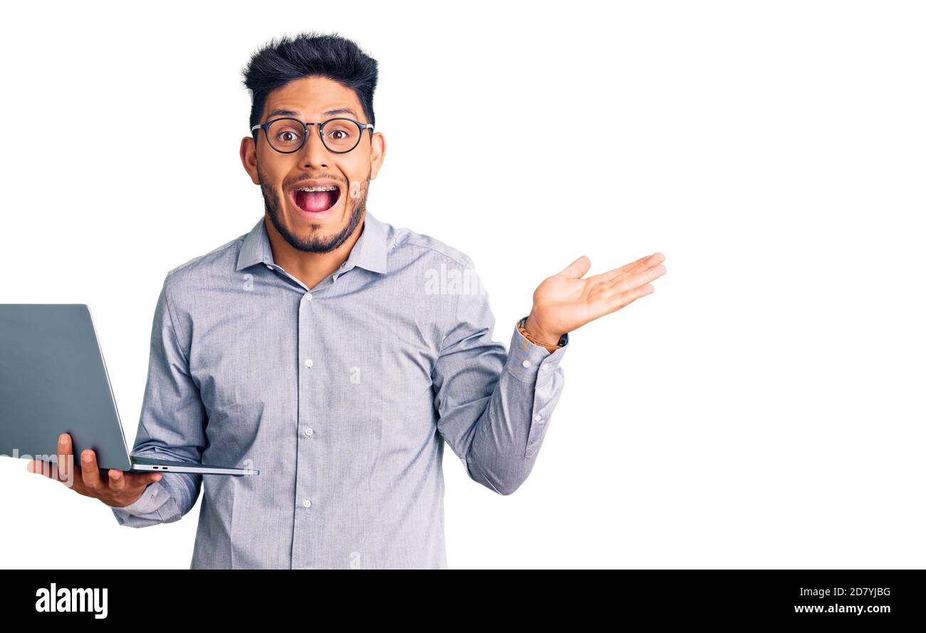 Handsome latin american young man working using computer laptop ...