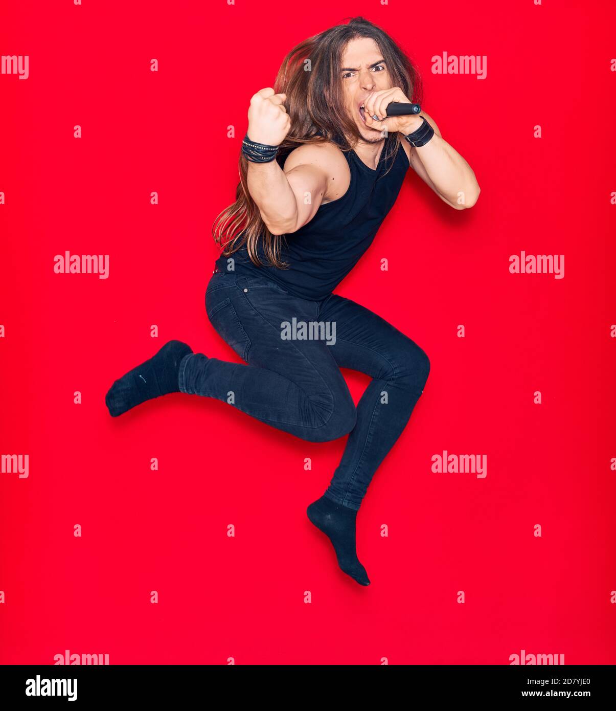 Young handsome heavy metal singer man with long hair and aggressive ...