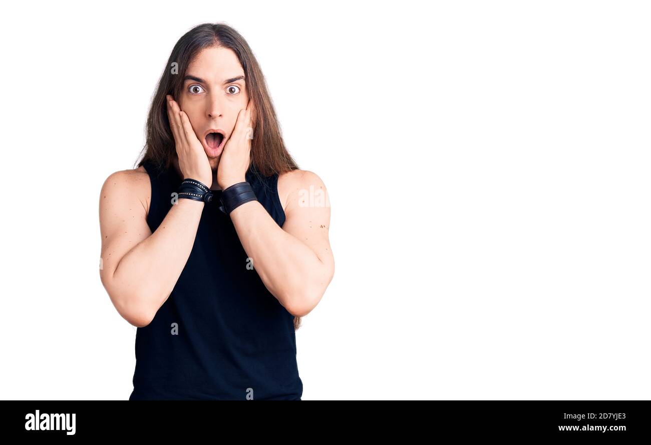 Young adult man with long hair wearing goth style with black clothes ...