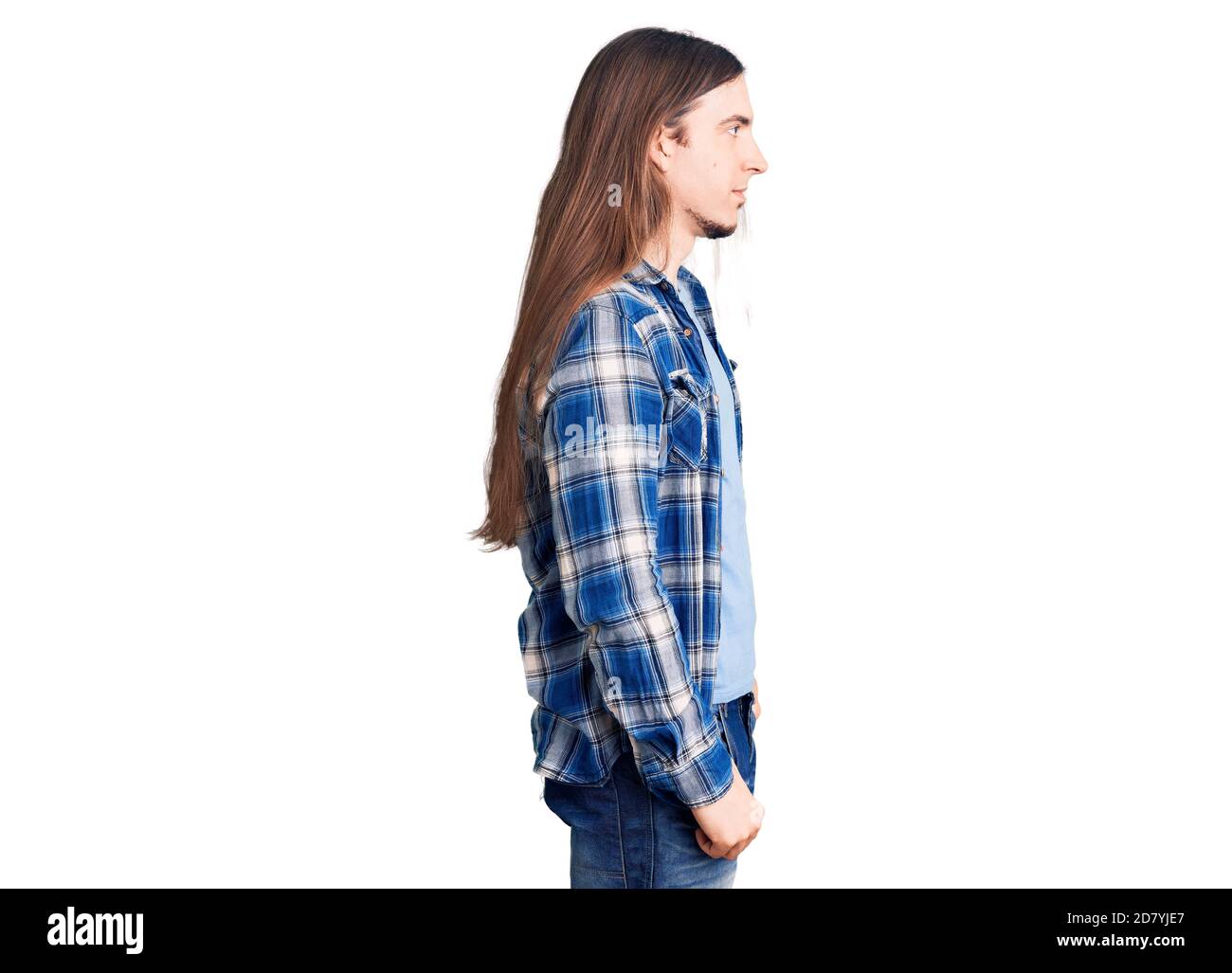 Young adult man with long hair wearing casual shirt looking to side ...