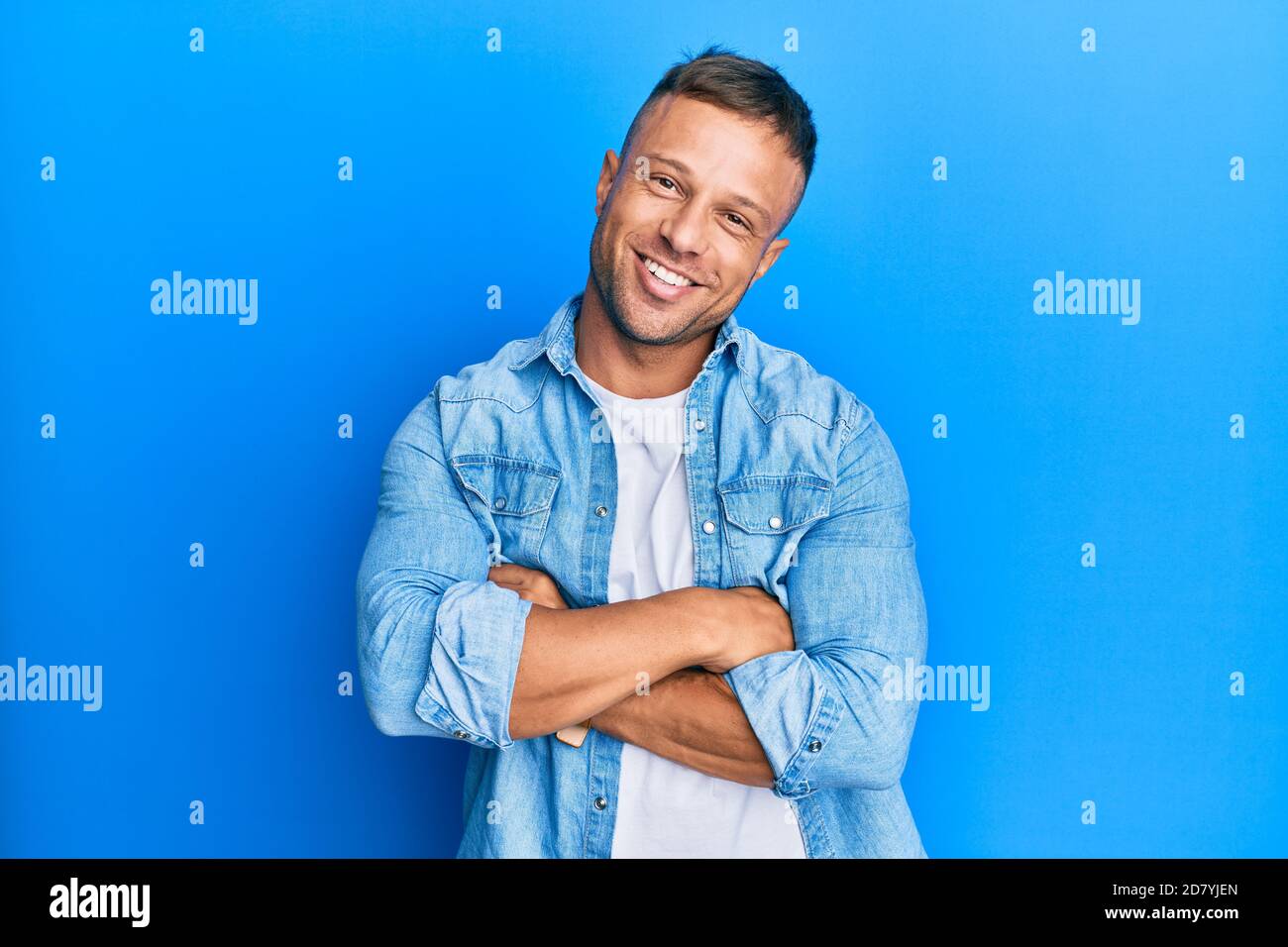 Handsome muscle man wearing casual denim jacket happy face smiling with ...