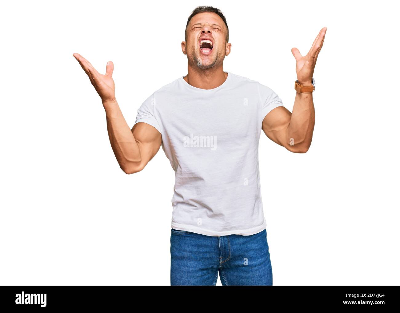 Handsome muscle man wearing casual white tshirt celebrating mad and ...