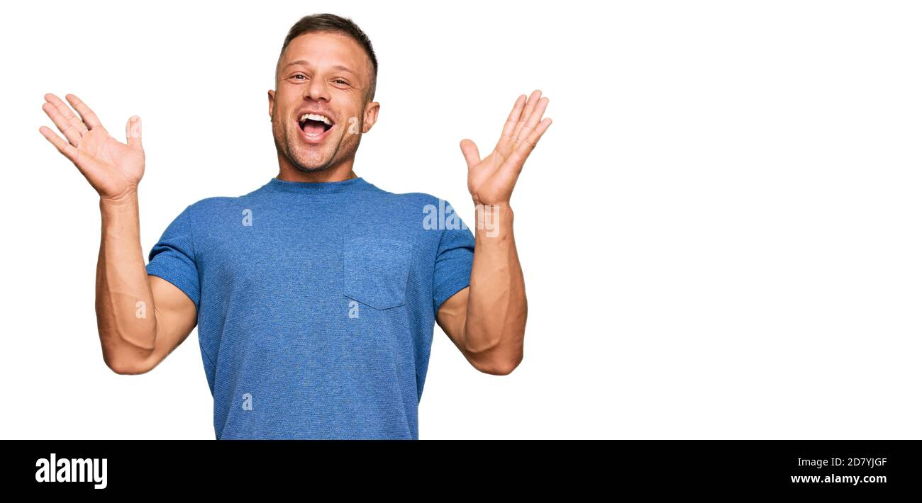 Handsome muscle man wearing casual clothes celebrating crazy and amazed ...