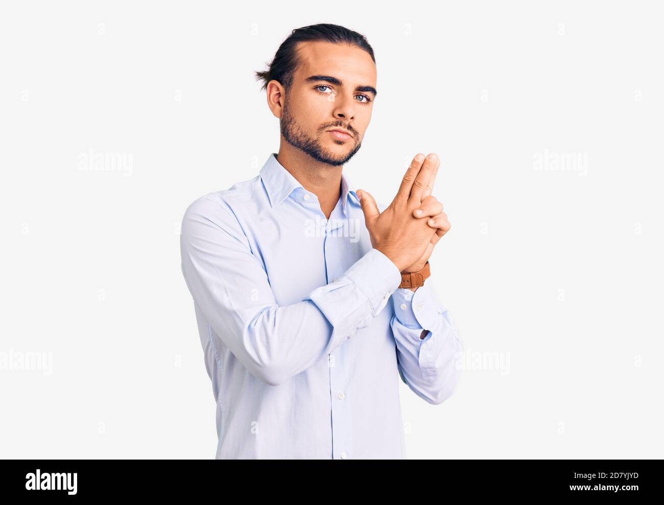 Young handsome man wearing business clothes holding symbolic gun with ...