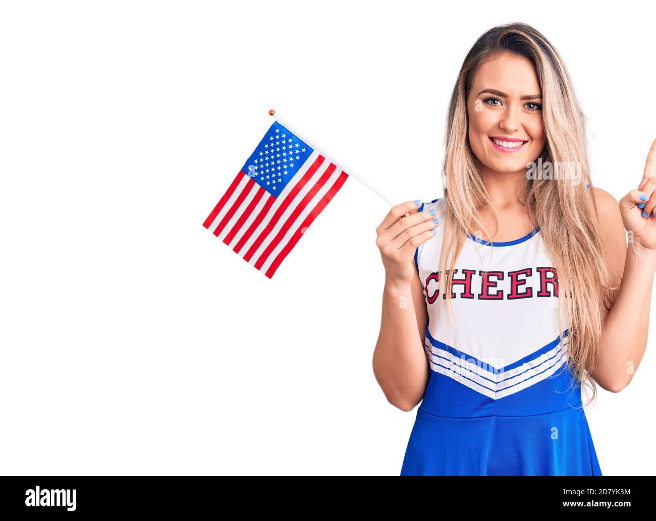 Young Beautiful Blonde Woman Wearing Cheerleader Uniform Holding United States Flag Surprised