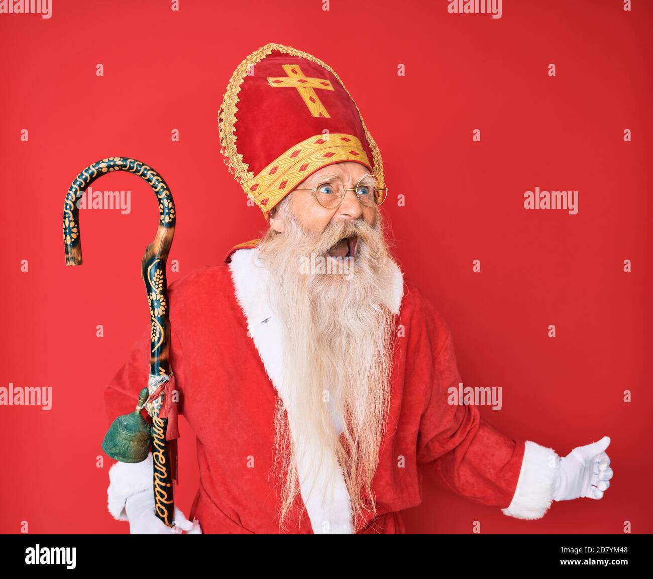 Old senior man with grey hair and long beard wearing traditional saint ...
