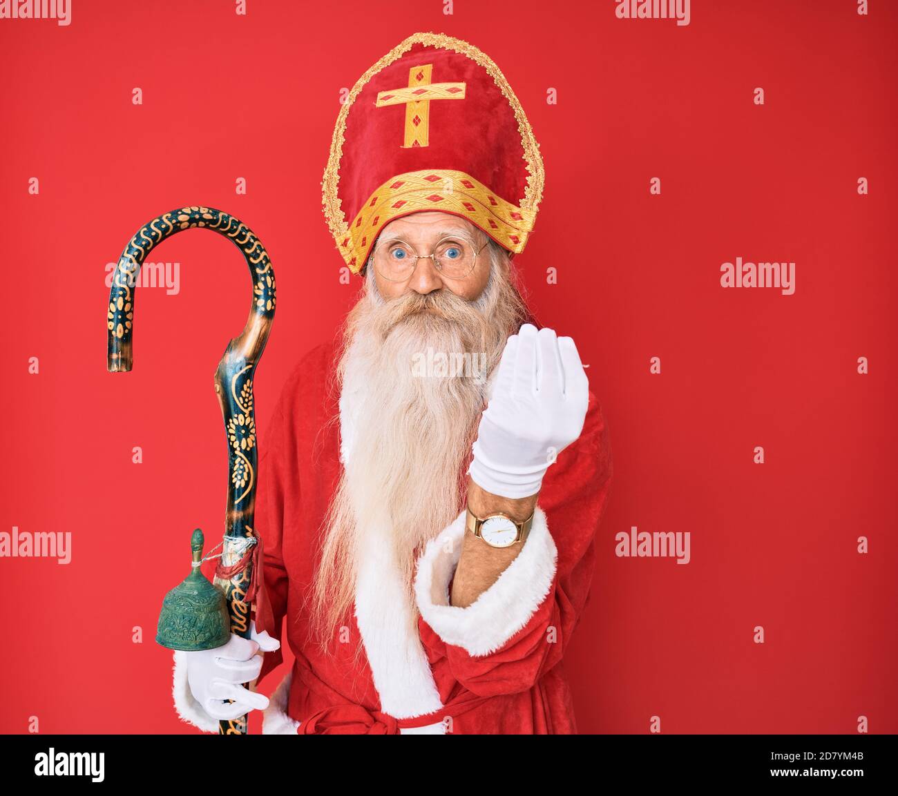 Old senior man with grey hair and long beard wearing traditional saint ...