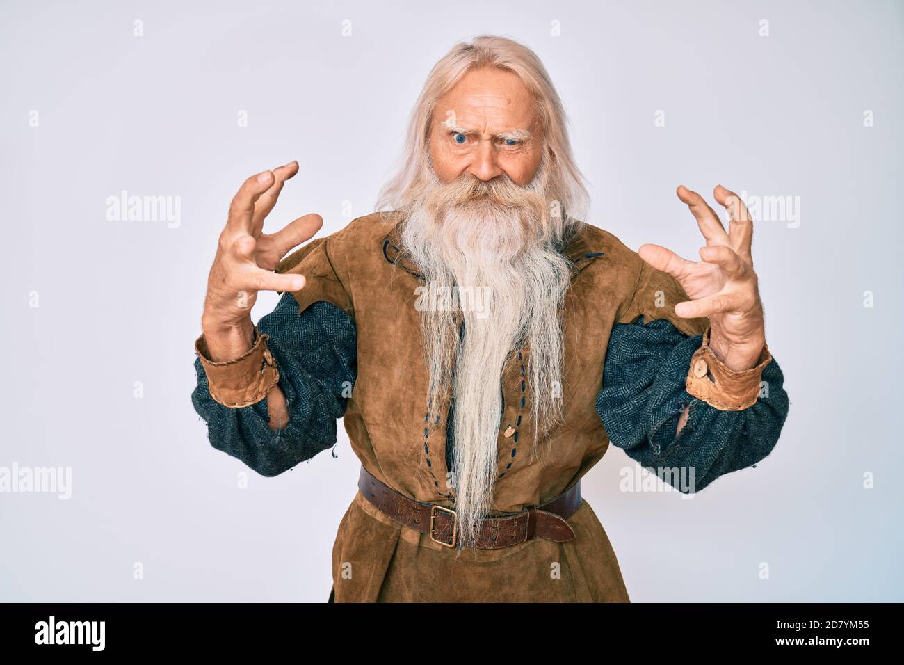 Old senior man with grey hair and long beard wearing viking traditional ...