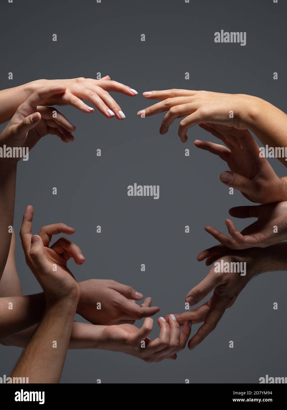 Rounded. Hands of people's crows in touch isolated on grey studio ...