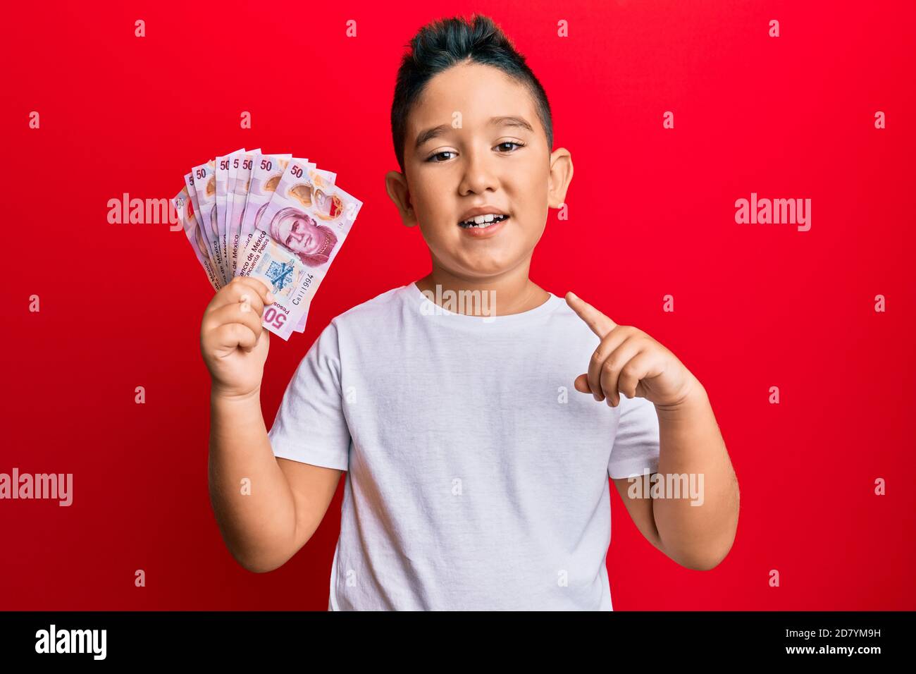 Little boy hispanic kid holding 50 mexican pesos banknotes smiling ...