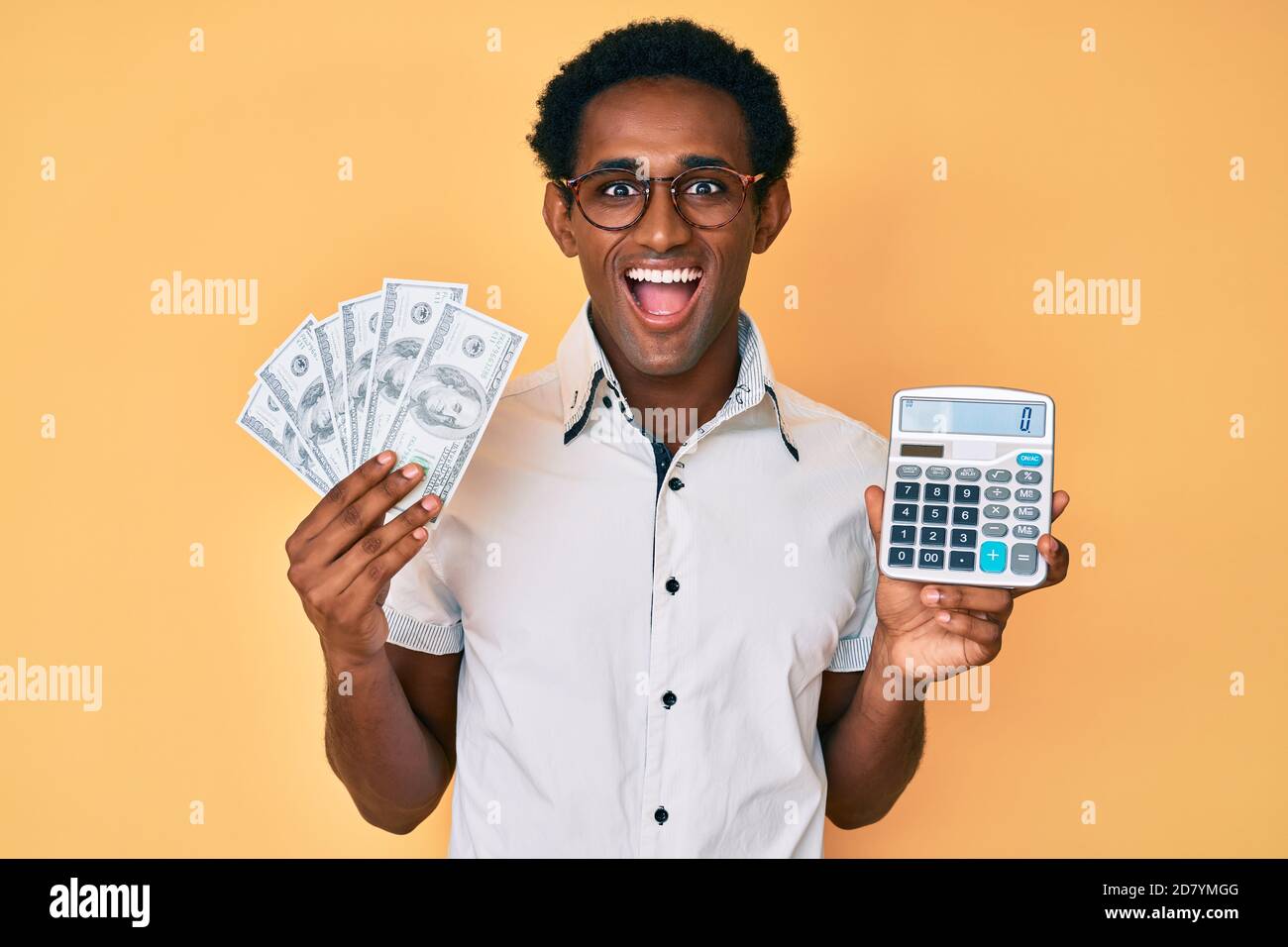African handsome man holding dollars calculating savings celebrating ...