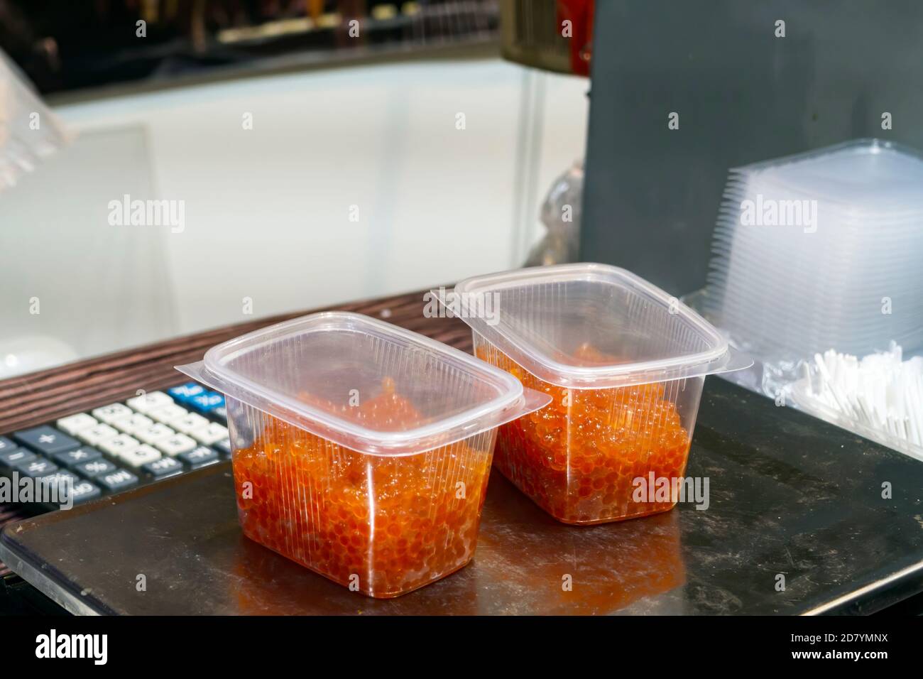 Red caviar in transparent containers stand on scales on market Stock ...