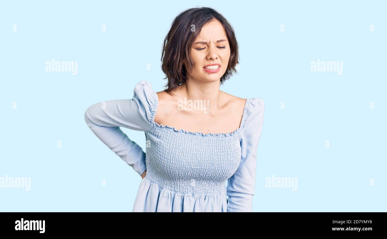 Young beautiful girl wearing casual clothes suffering of backache ...