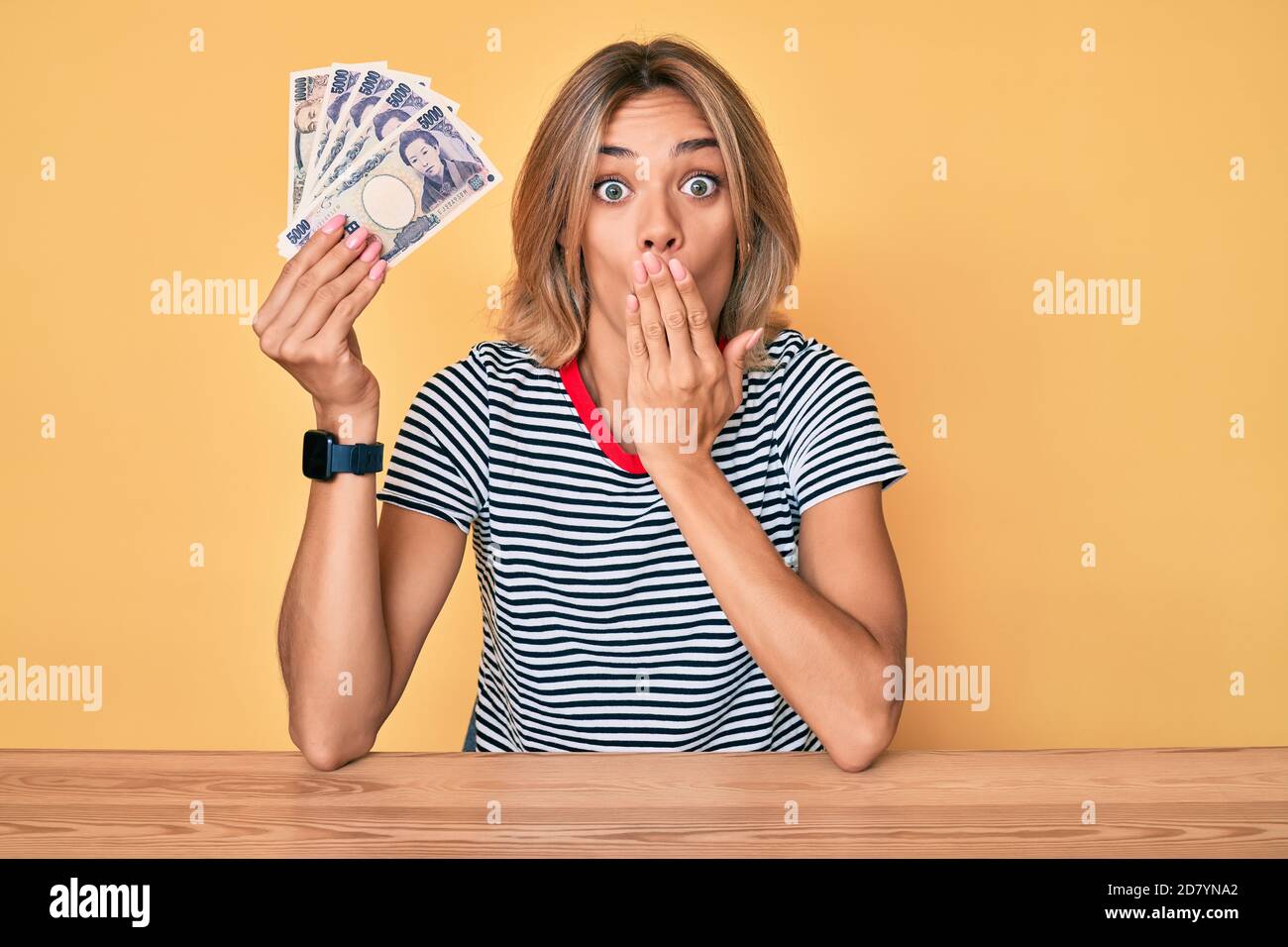 Beautiful caucasian woman holding japanese yen banknotes covering mouth ...