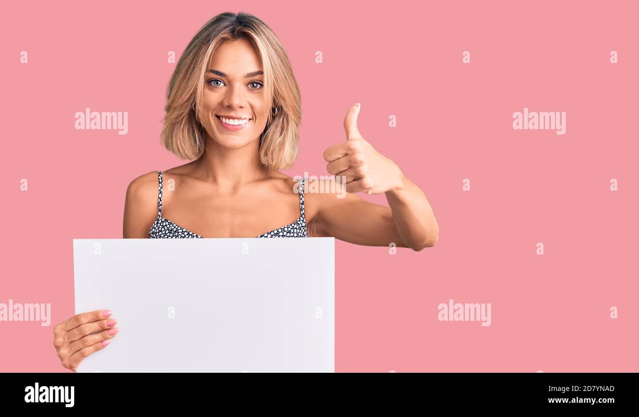 Beautiful caucasian woman holding blank empty banner smiling happy and ...