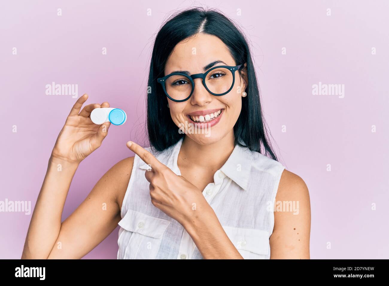 Beautiful young woman holding glasses and contact lenses smiling happy ...