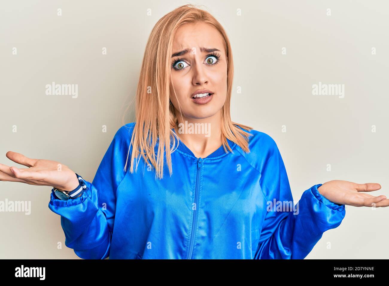 Beautiful caucasian woman wearing sportswear clueless and confused with ...
