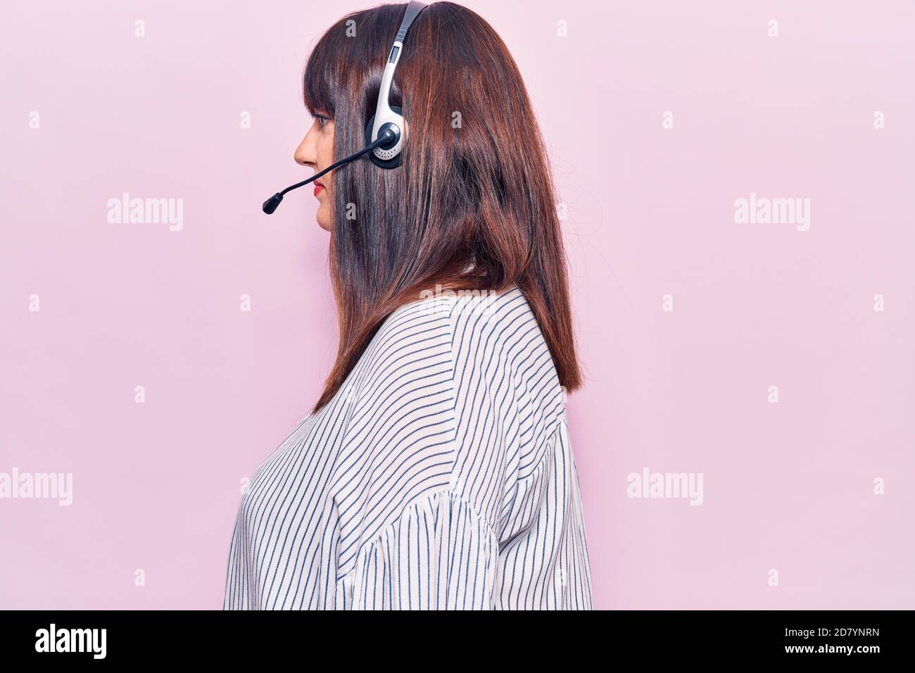Young plus size woman wearing call center agent headset looking to side ...