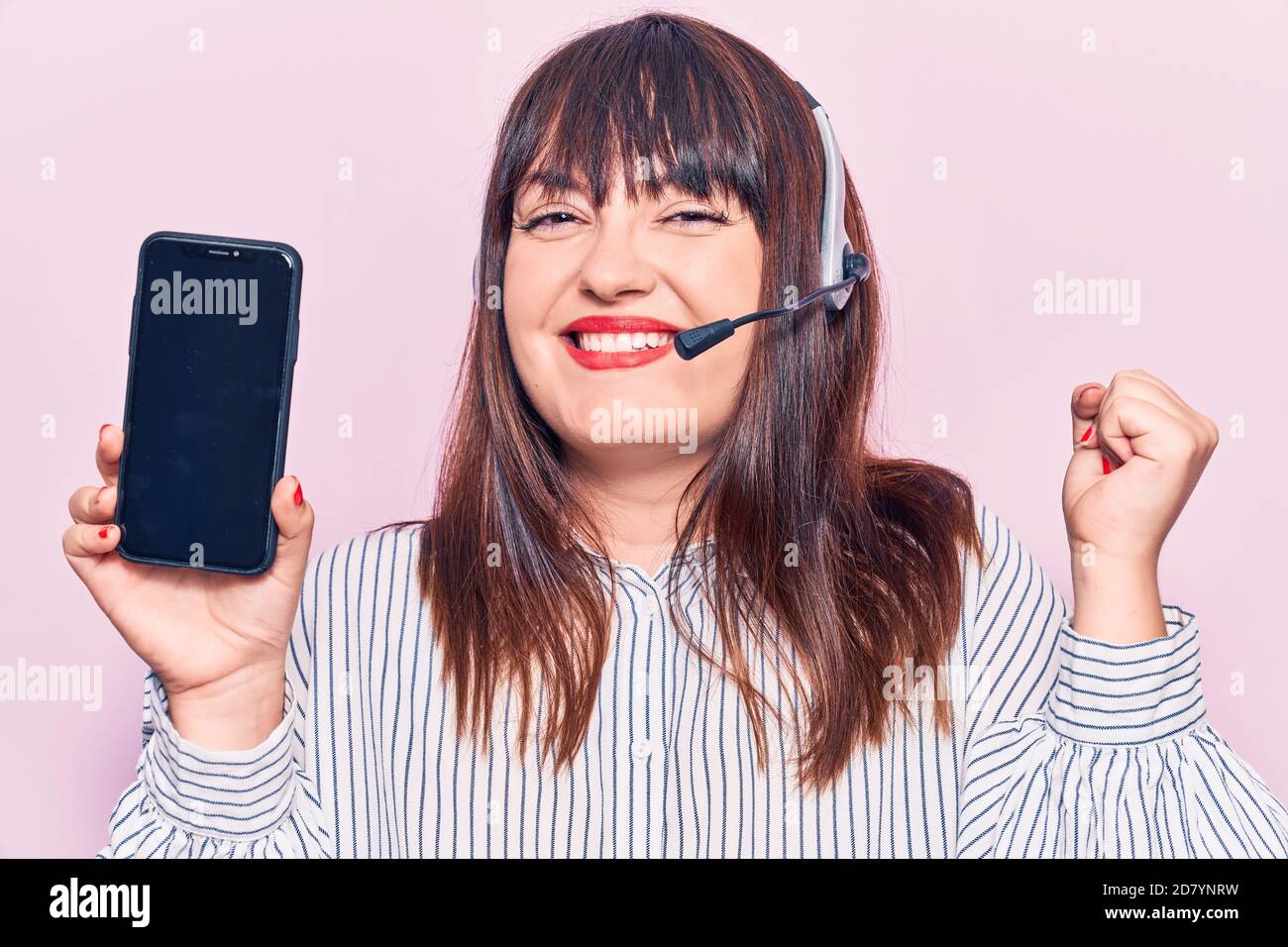 Young plus size woman wearing call center agent headset holding ...