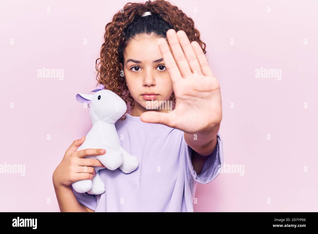 Beautiful kid girl with curly hair holding animal doll toy with open ...