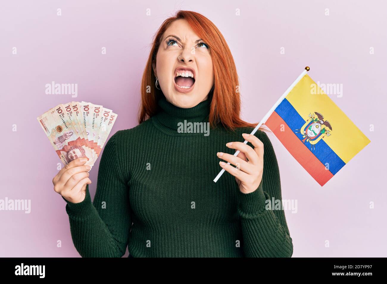 Beautiful redhead woman holding colombia flag and 10 colombian pesos ...