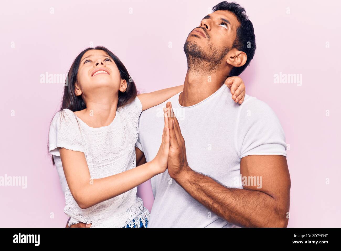 Young father and daughter wearing casual clothes begging and praying ...