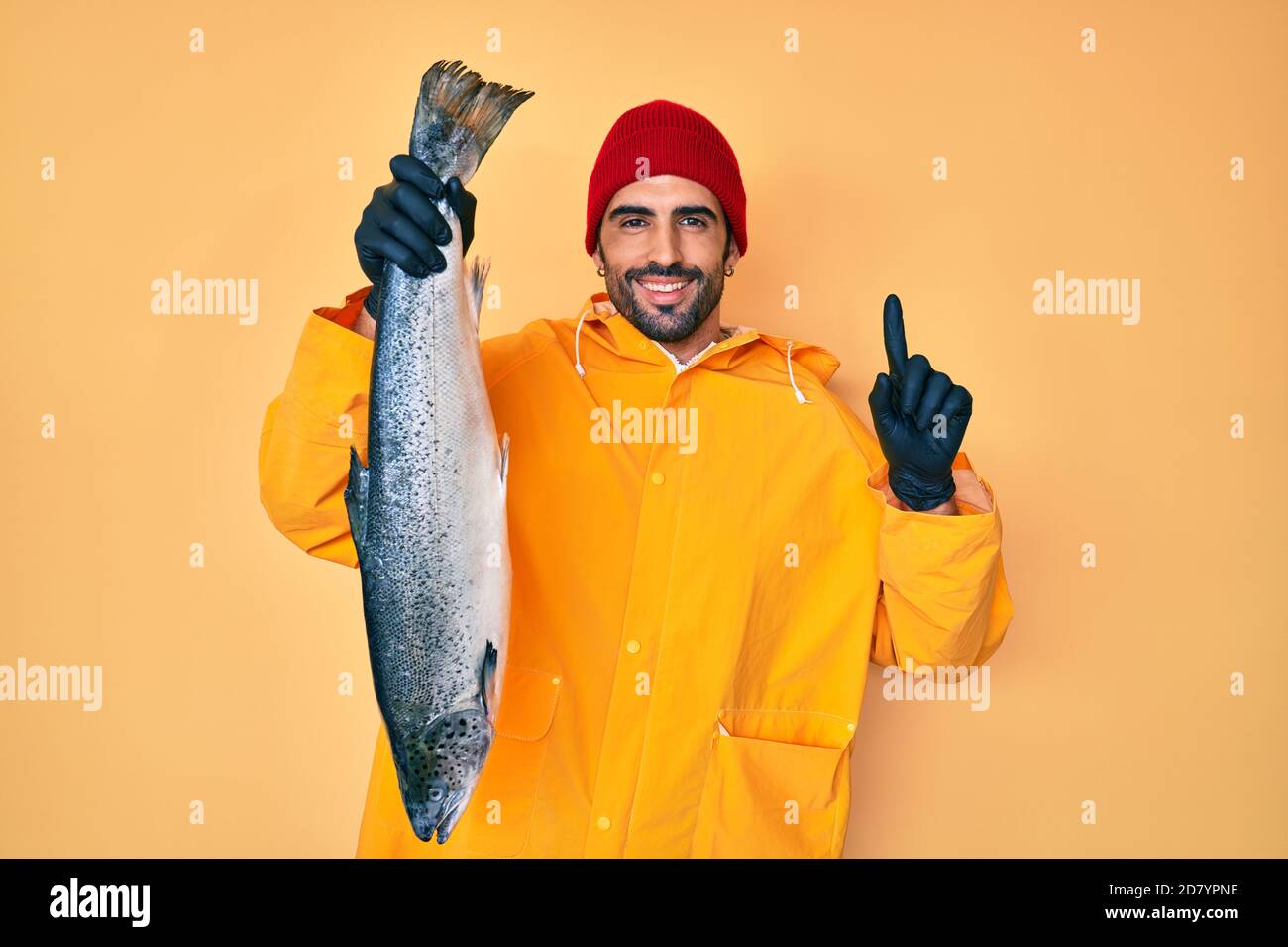 Handsome hispanic man with beard wearing fisherman equipment surprised ...