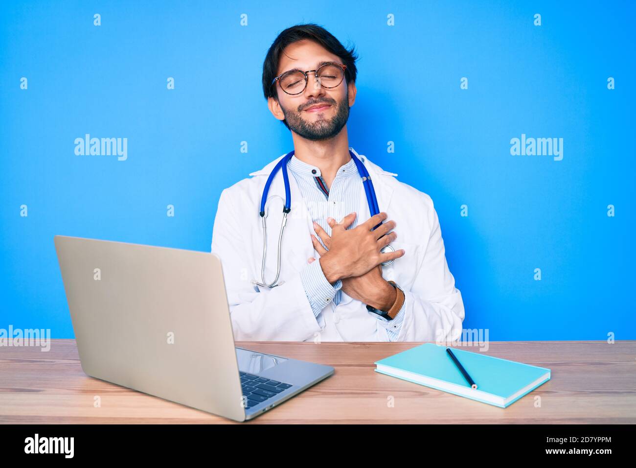 Handsome hispanic man wearing doctor uniform working at the clinic ...