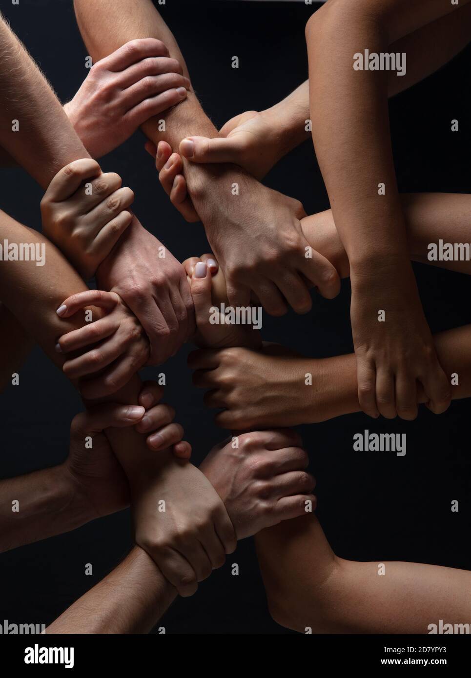 Forces. Hands of people's crows in touch isolated on black studio ...