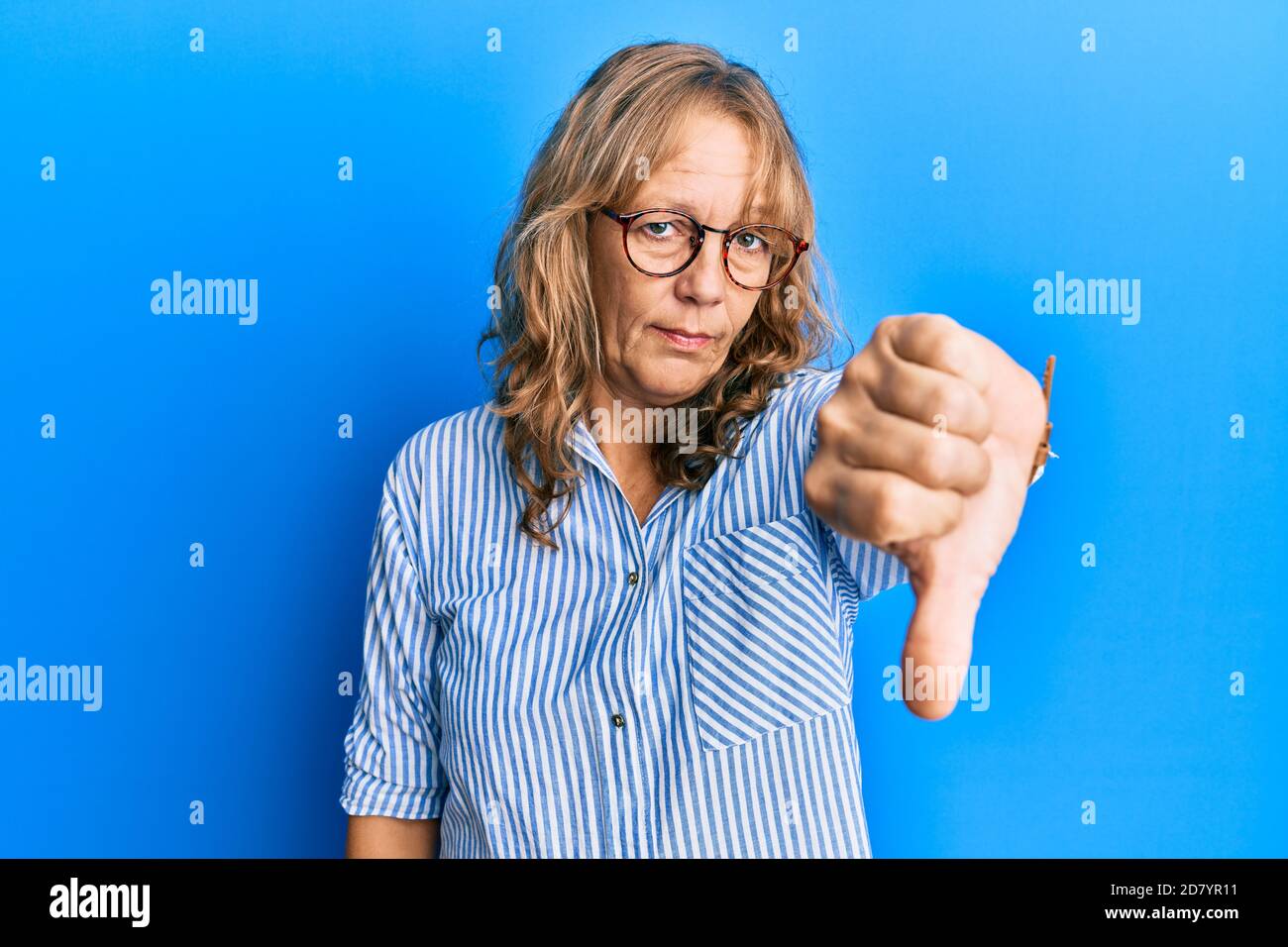 Middle age blonde woman wearing casual clothes and glasses looking ...