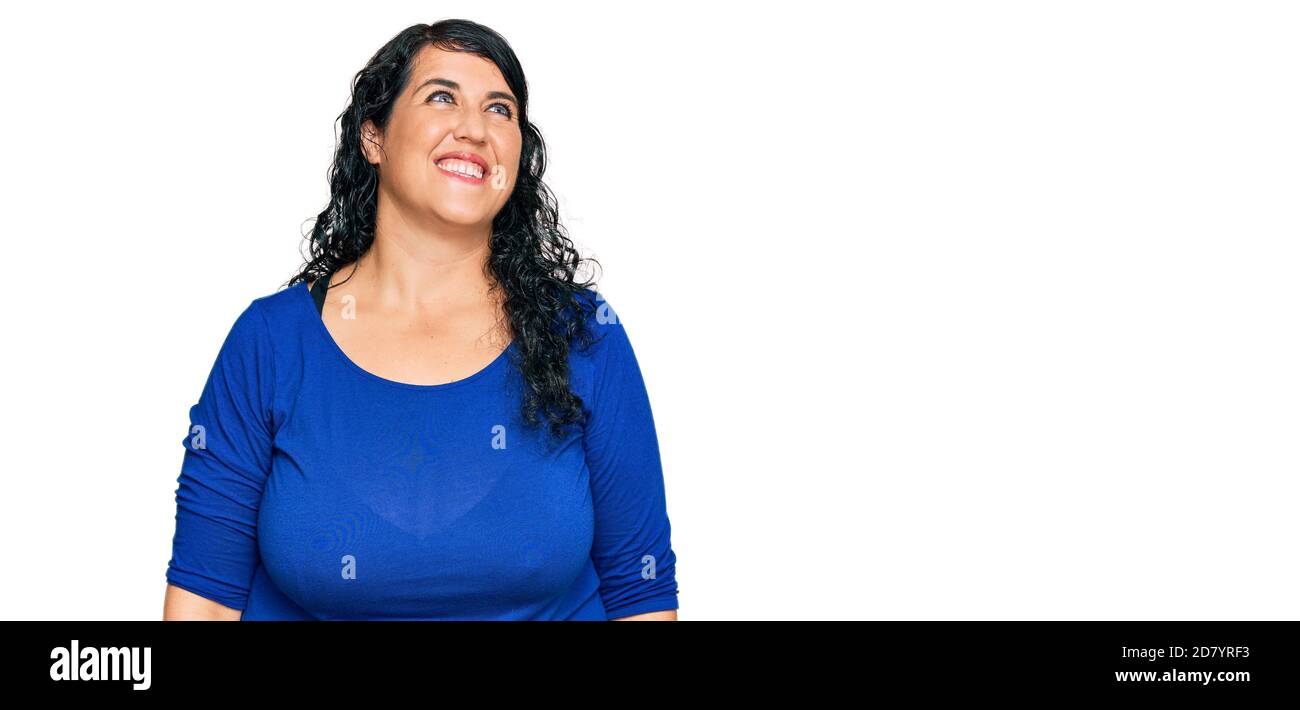 Plus size brunette woman wearing casual clothes looking away to side ...