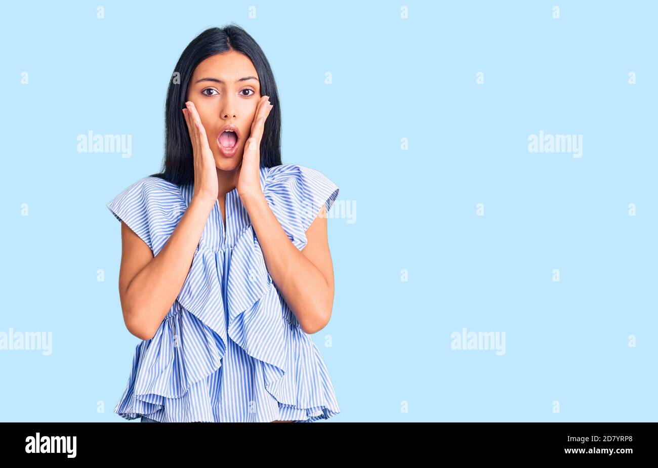 Young beautiful latin girl wearing casual clothes afraid and shocked ...