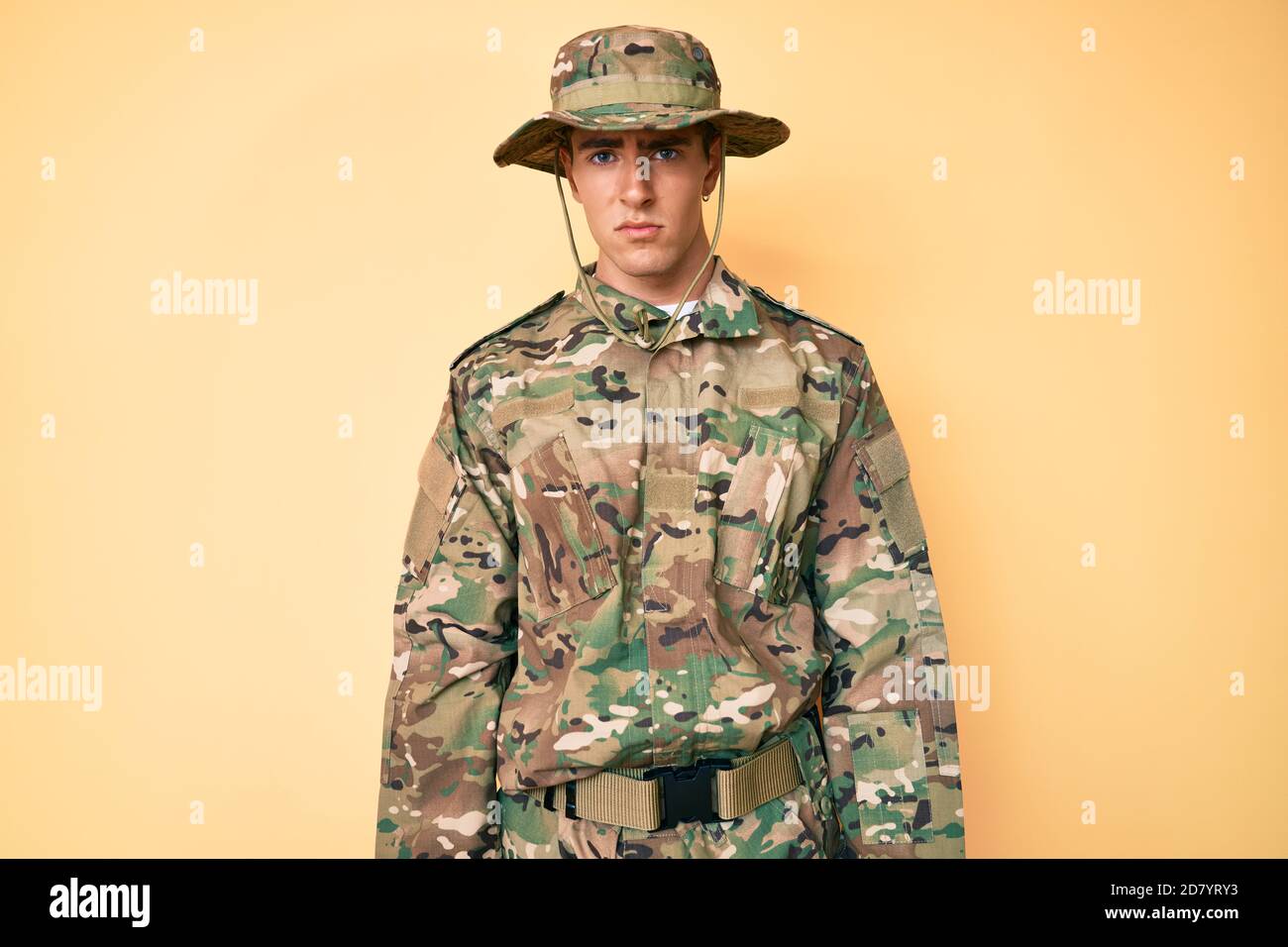 Young handsome man wearing camouflage army uniform skeptic and nervous ...