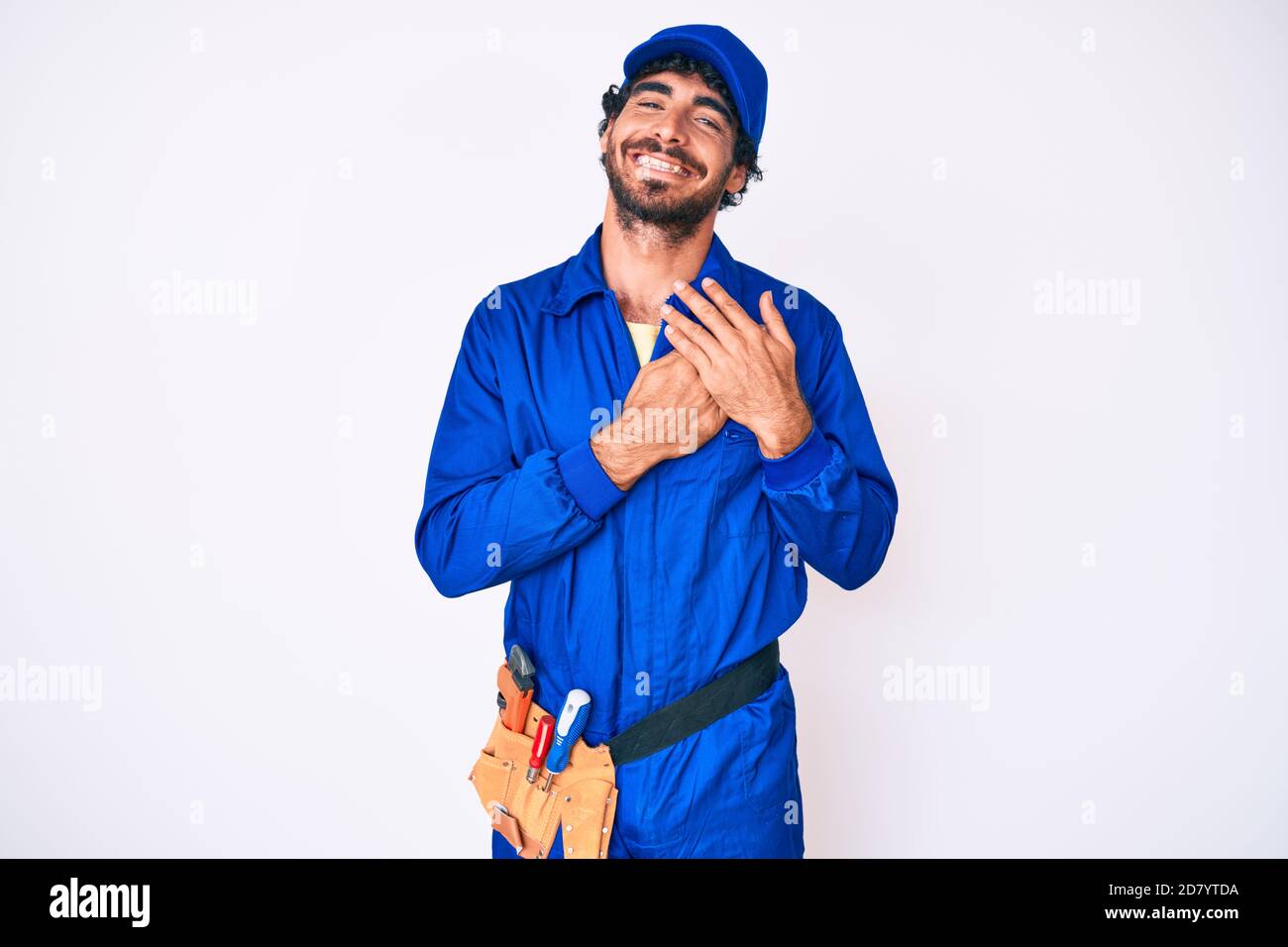 Handsome young man with curly hair and bear weaing handyman uniform ...