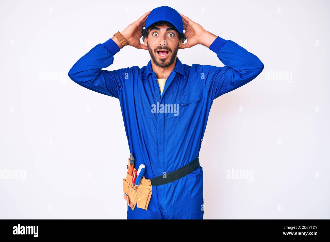 Handsome young man with curly hair and bear weaing handyman uniform ...