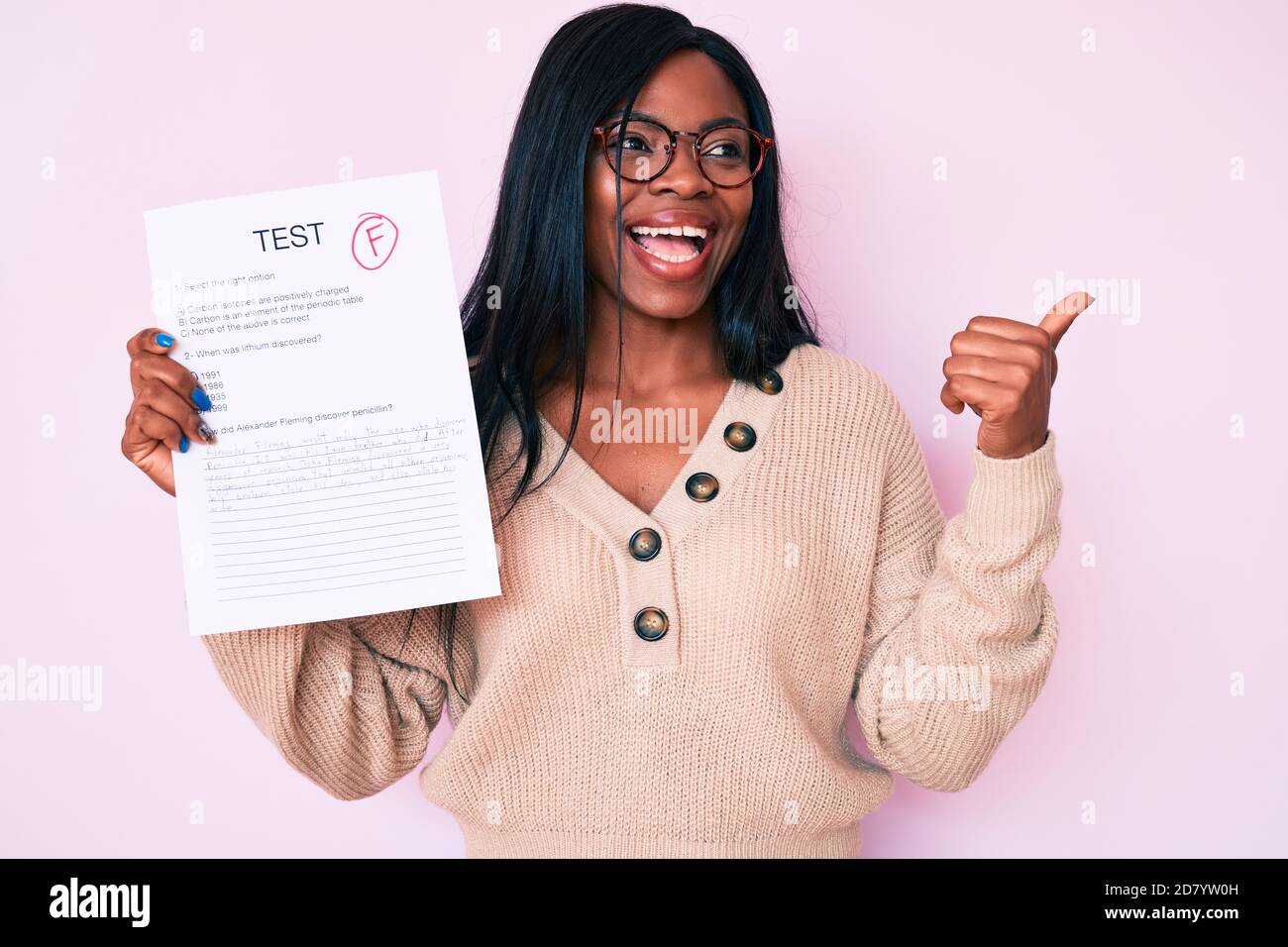 Young african american woman showing a failed exam pointing thumb up to ...