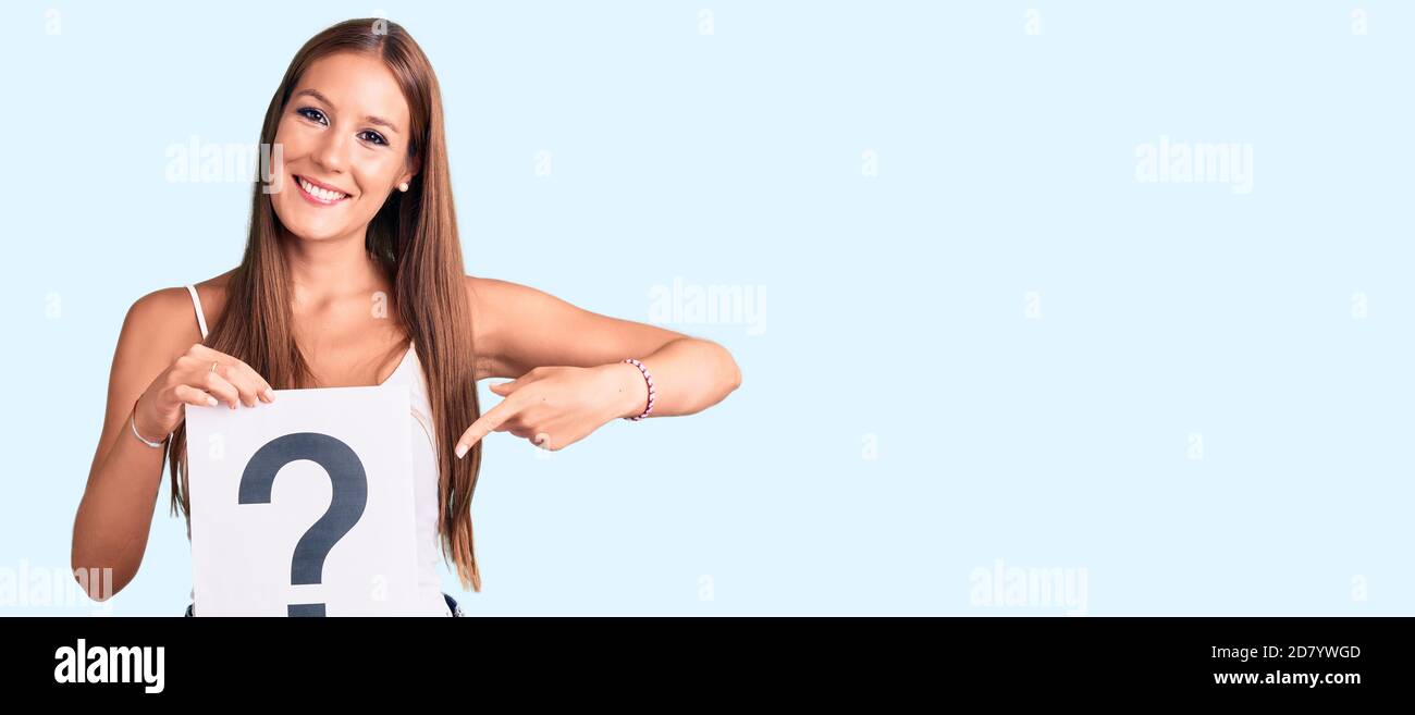 Young beautiful hispanic woman holding question mark smiling happy ...