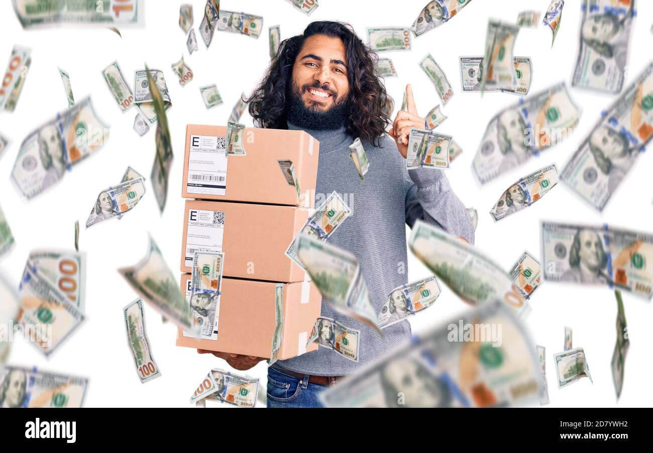 Young arab man holding delivery package surprised with an idea or ...