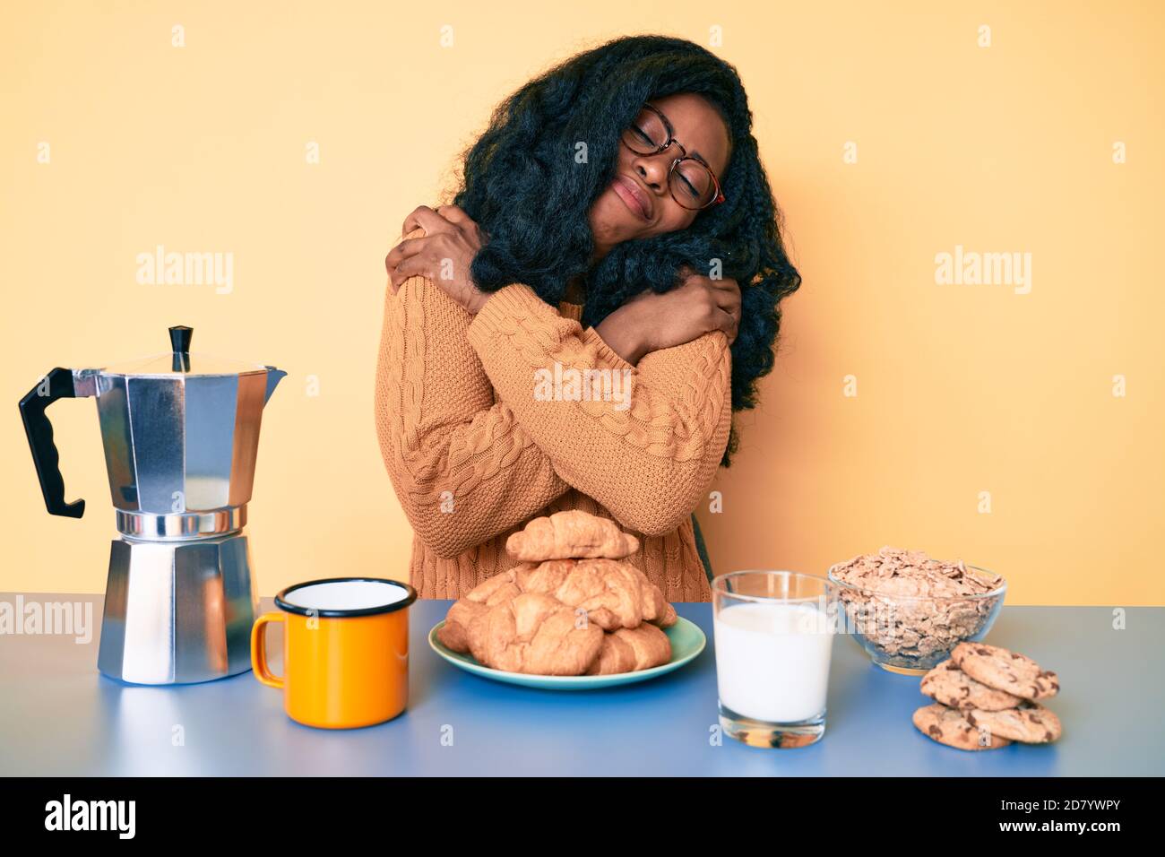 Beautiful african woman sitting on the table eating breakfast in the ...