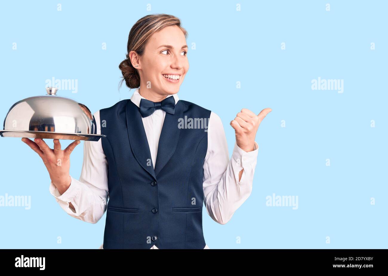Young beautiful blonde woman wearing waitress uniform holding tray ...