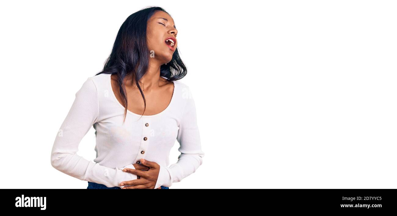 Young indian girl wearing casual clothes with hand on stomach because ...