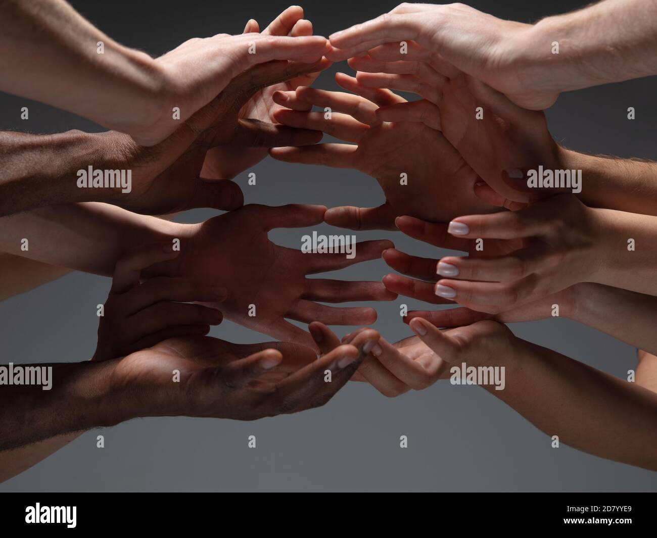 Save. Hands of people's crows in touch isolated on grey studio ...