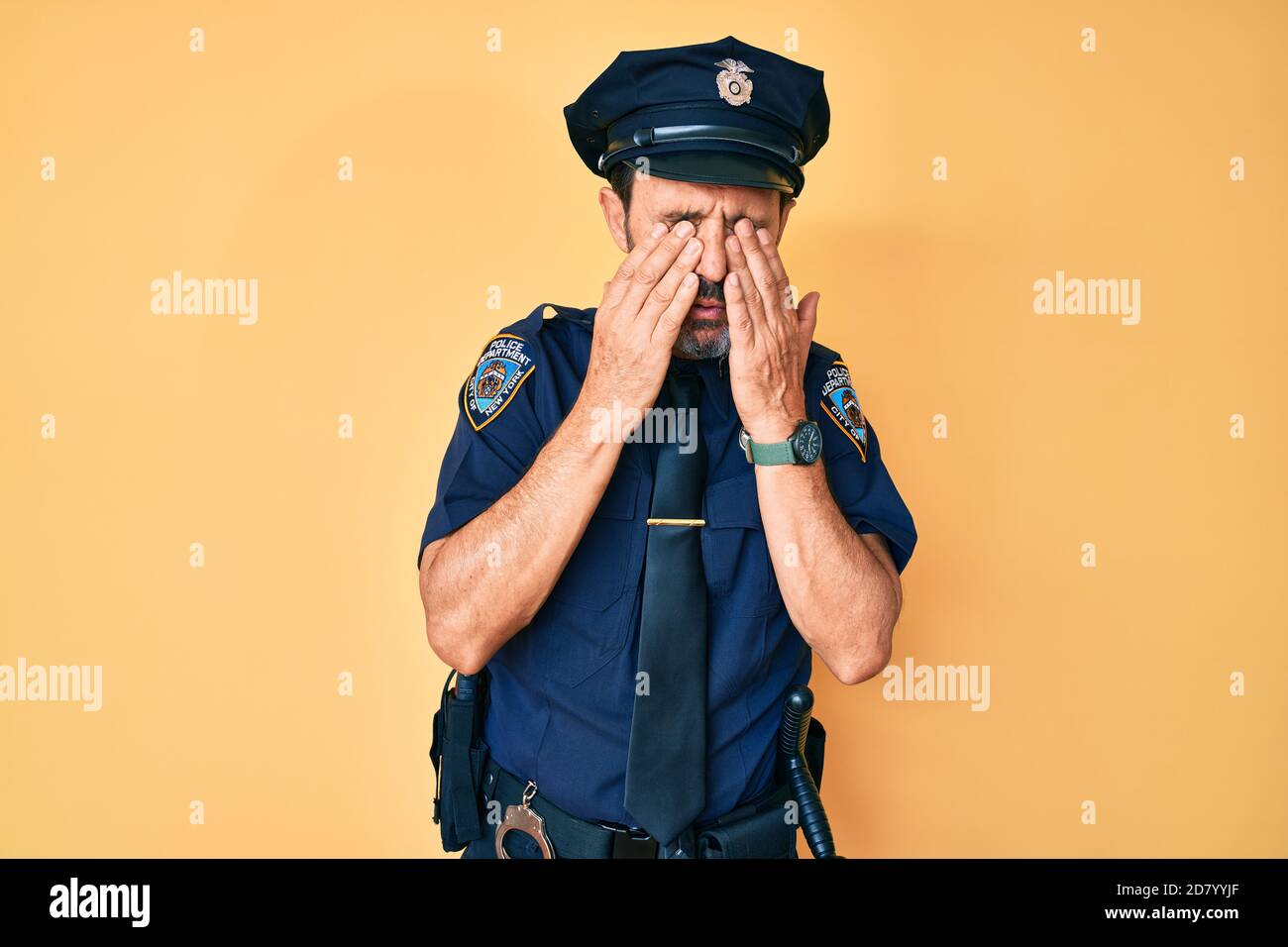 Middle age hispanic man wearing police uniform rubbing eyes for fatigue ...