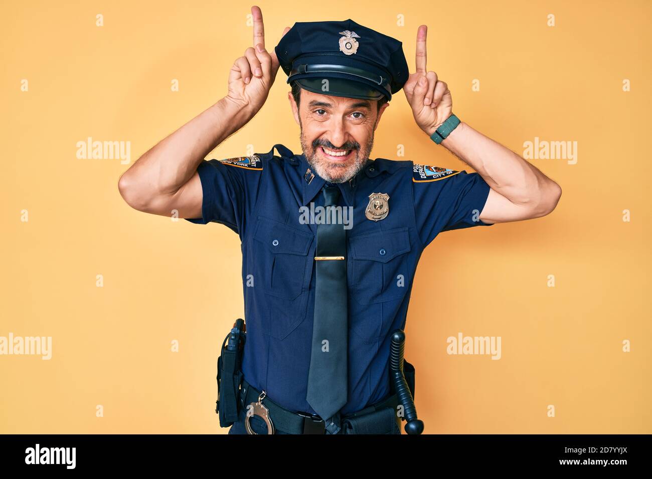 Middle age hispanic man wearing police uniform posing funny and crazy ...