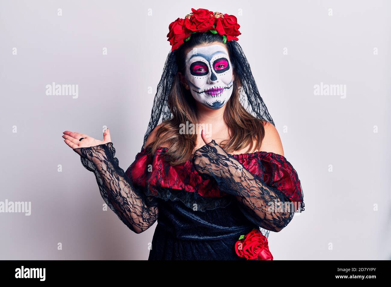 Young woman wearing day of the dead costume over white showing palm ...